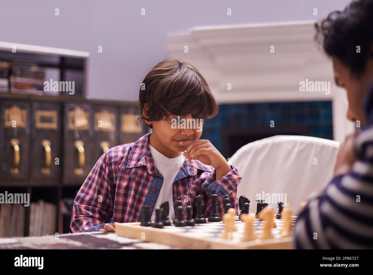 Planning his next move. a father and son playing chess at home Stock ...
