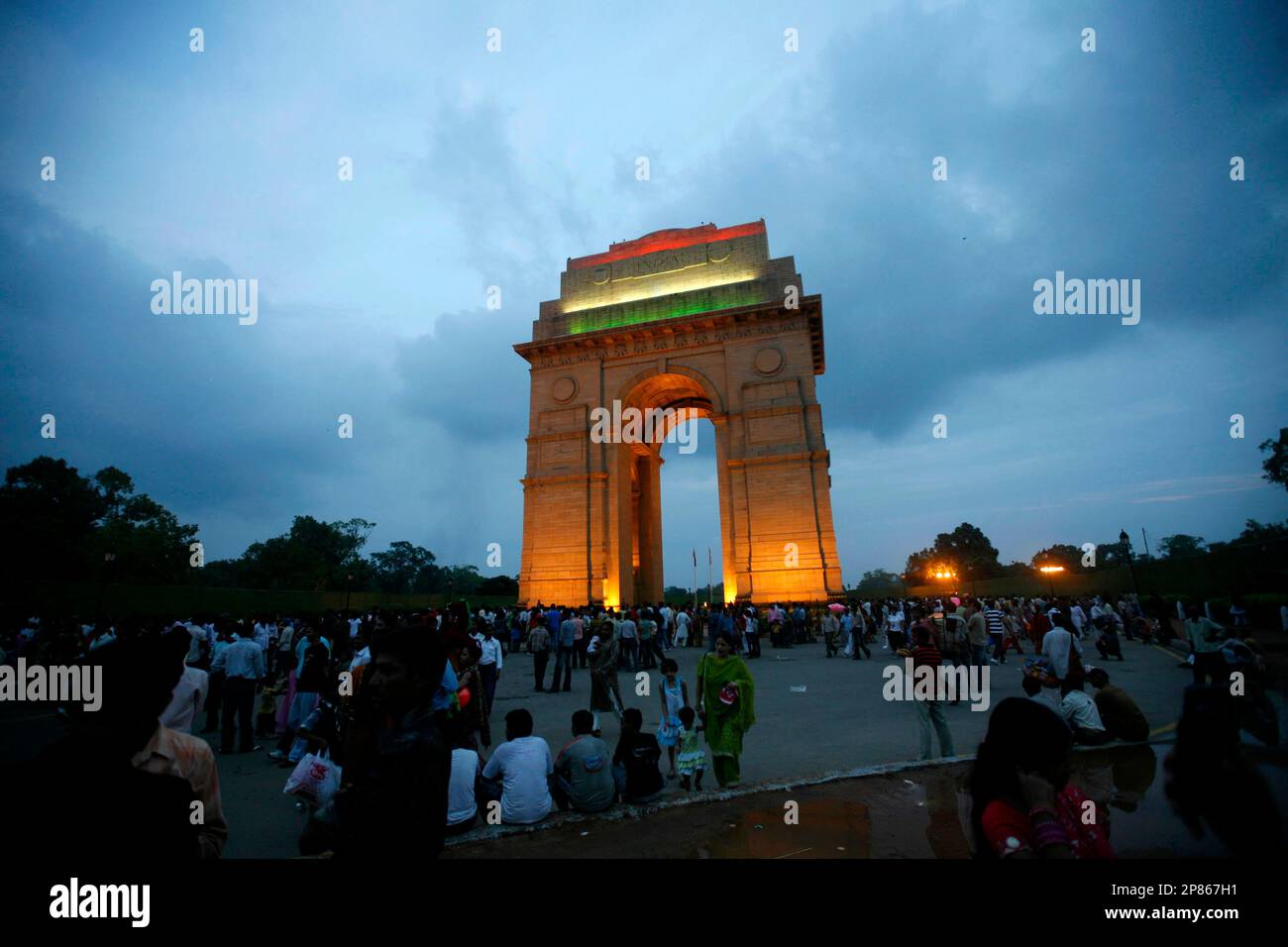 People enjoy an evening out at the India Gate war memorial, illuminated ...