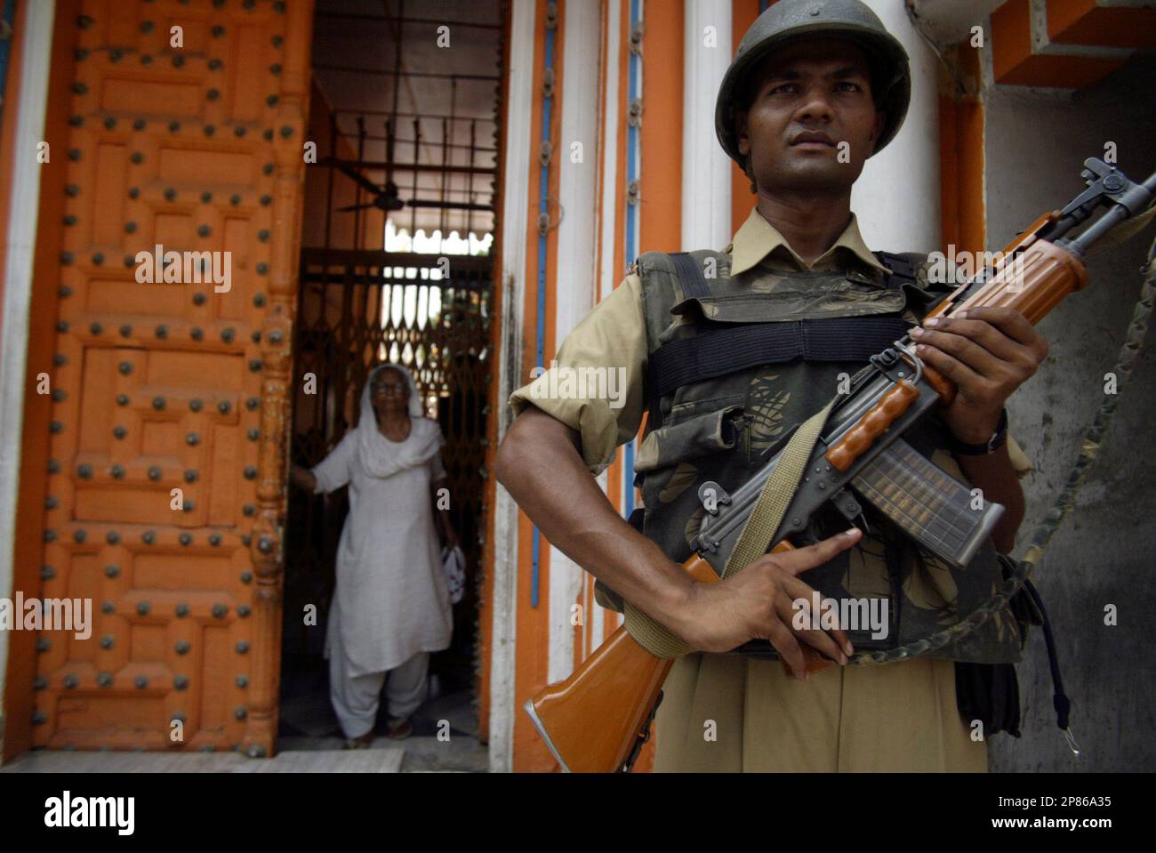 A paramilitary soldier stands guard outside the Raghunath temple, as an ...