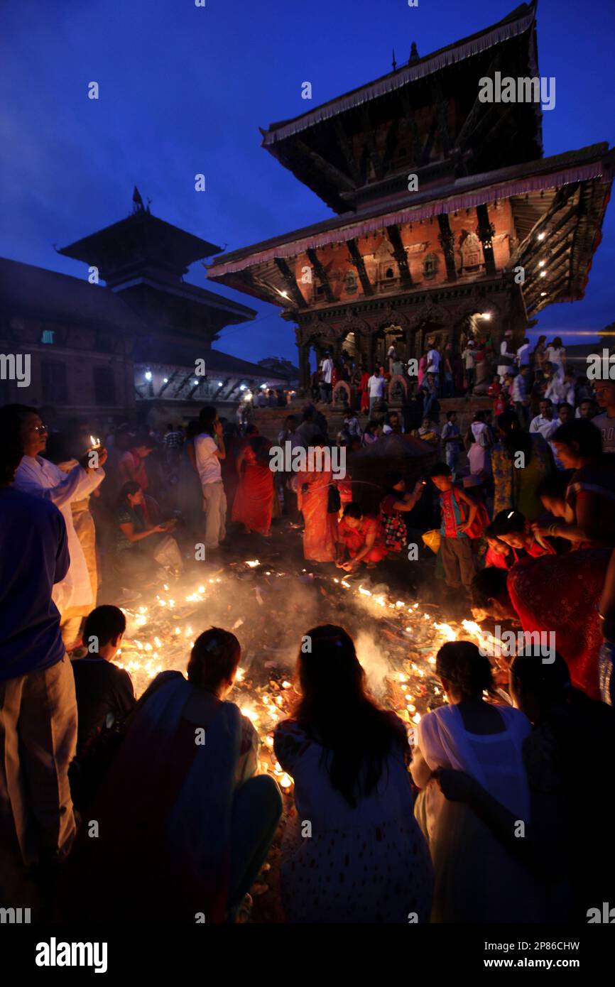 Hindu devotees perform rituals at a temple of Hindu God Krishna during ...