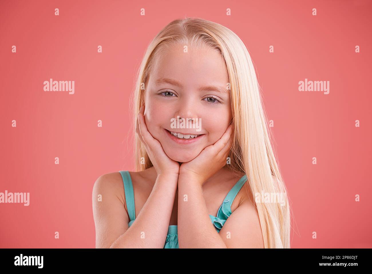 You are so sweet. Studio shot of a young girl posing on an orange ...