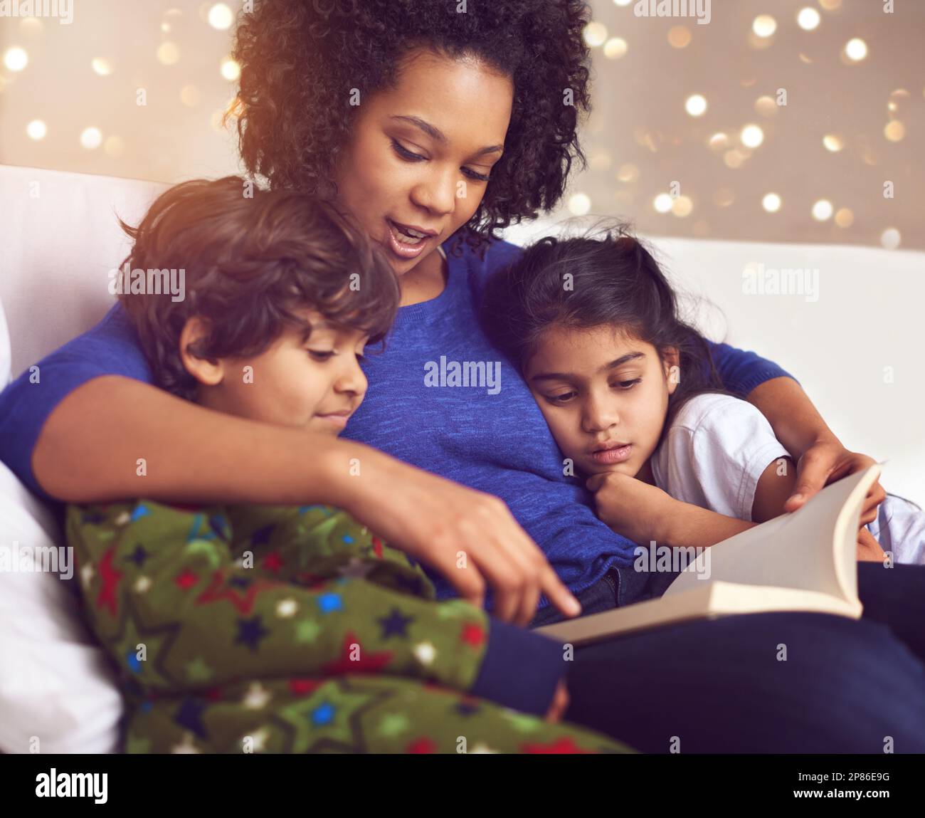 Once upon a time...a mother reading to her children at home Stock Photo ...