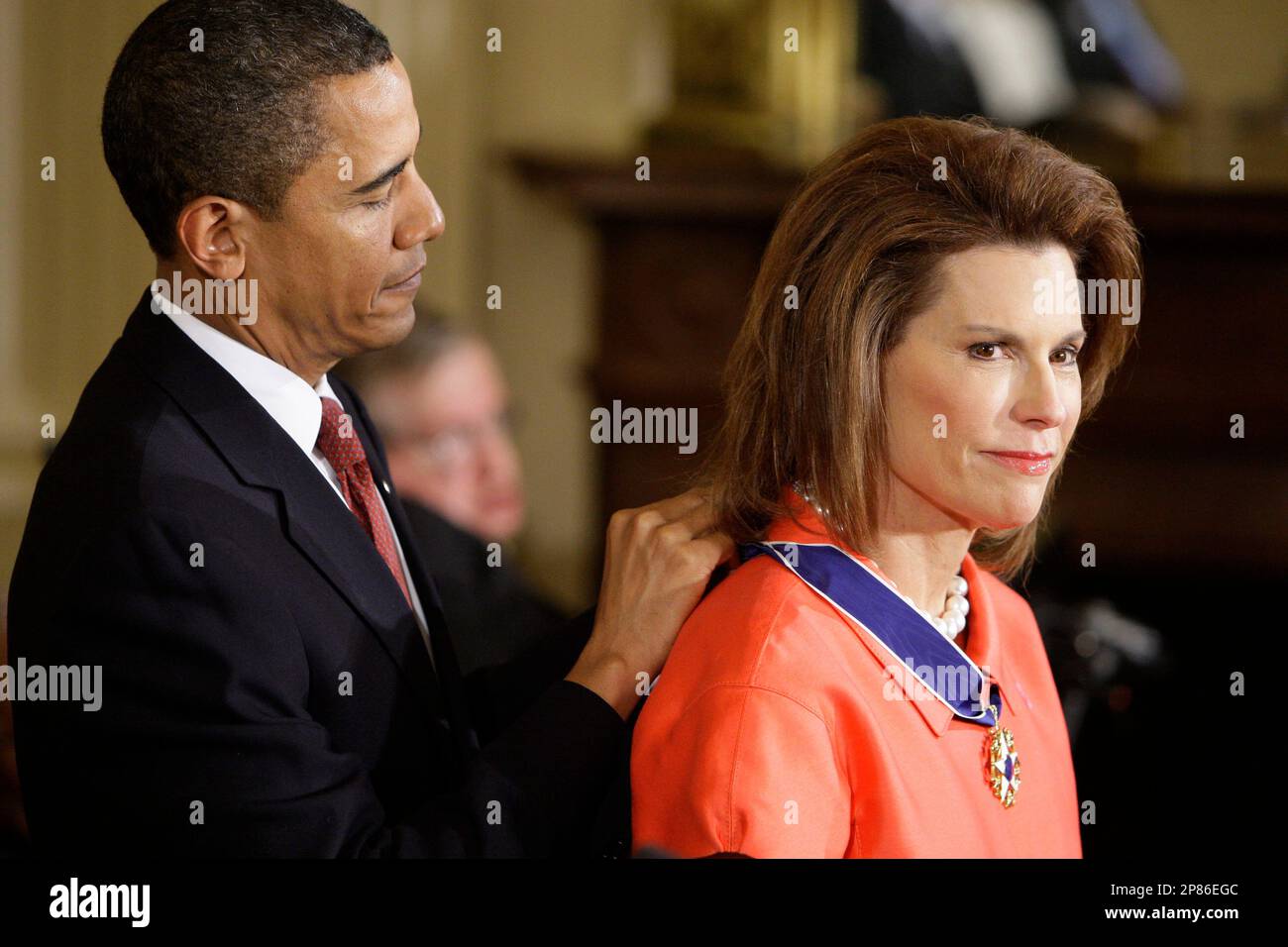 President Barack Obama places the medal around the neck of Nancy ...