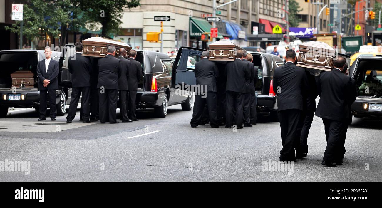 Pallbearers carry caskets to five awaiting hearses at the Frank E ...