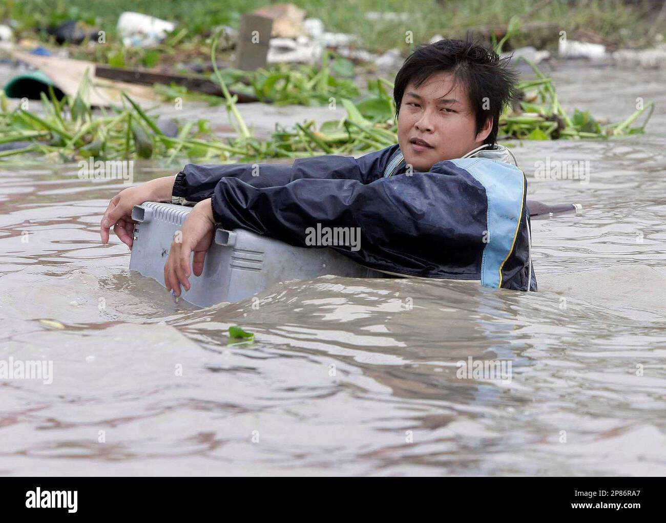A Taiwanese man floats in floodwater in Chiatung Town, Pintung County ...