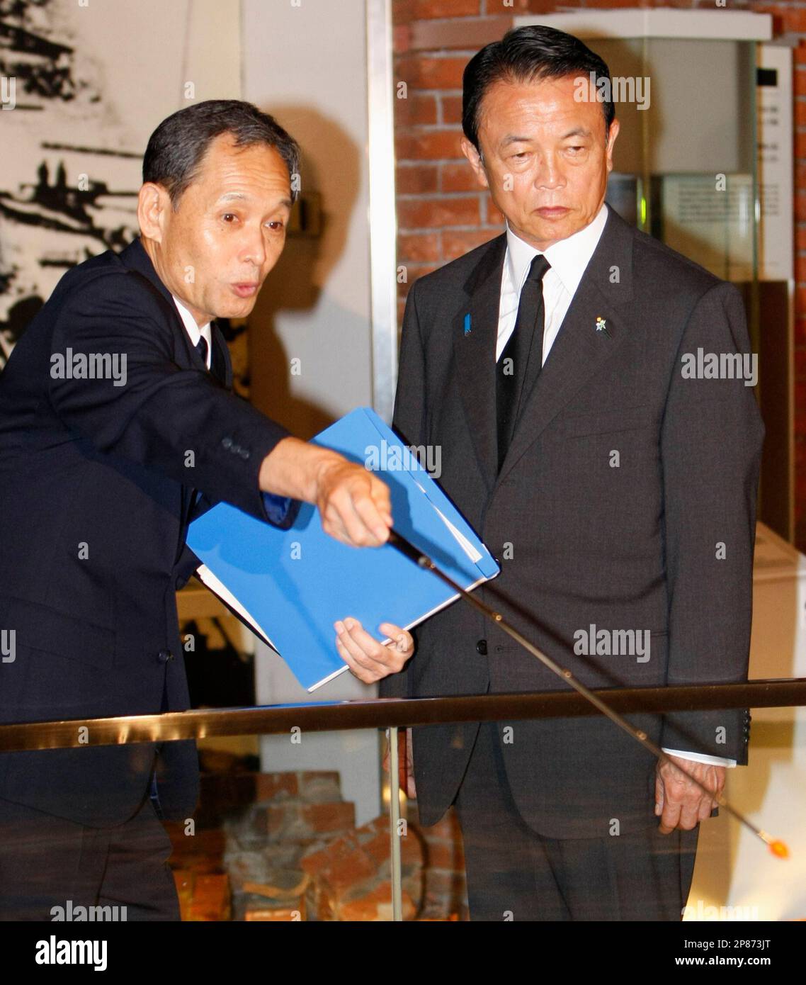Japanese Prime Minister Taro Aso, right, looks at a scale model of a ...