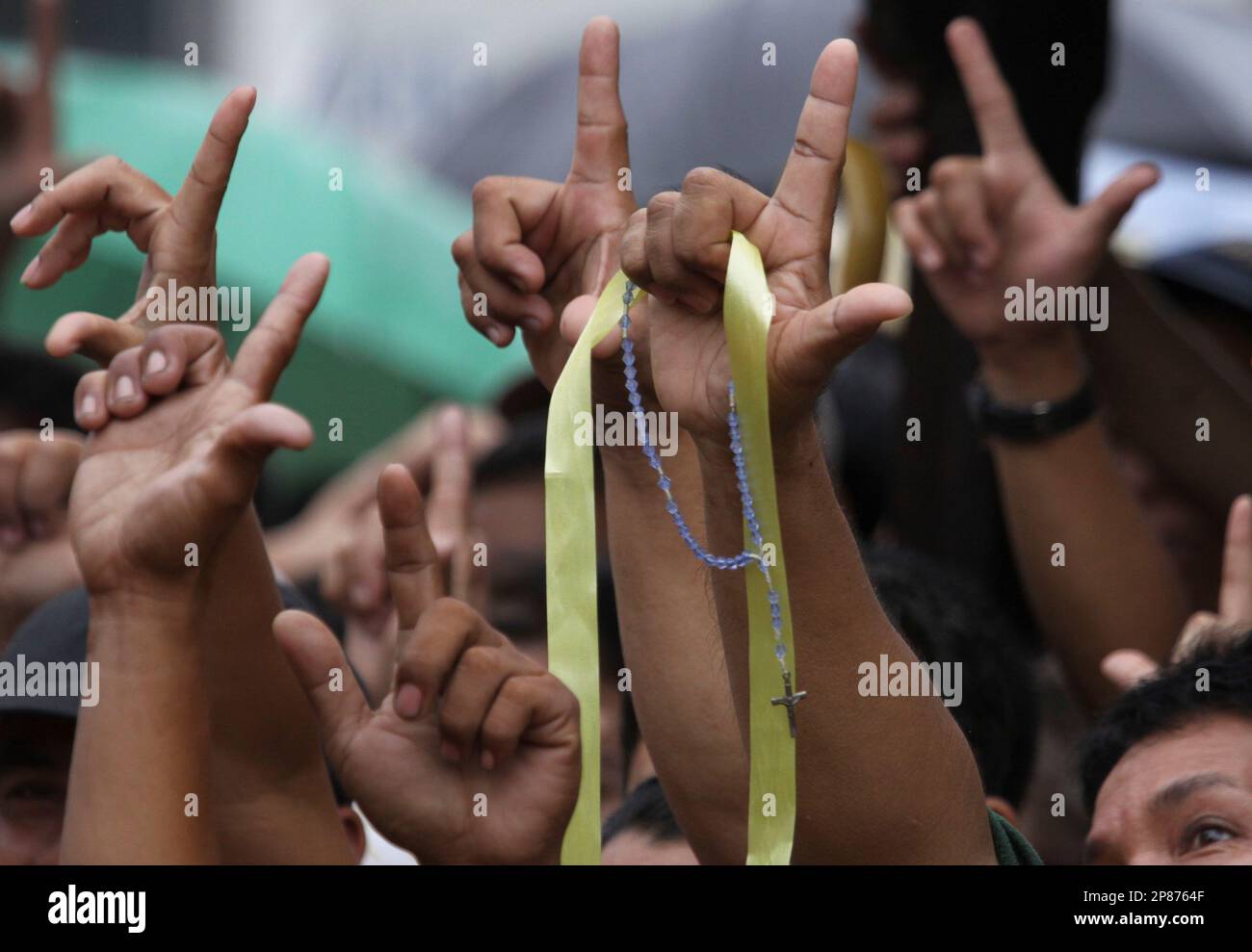 Filipinos flash the "laban" sign, means "fight" as they view the casket ...