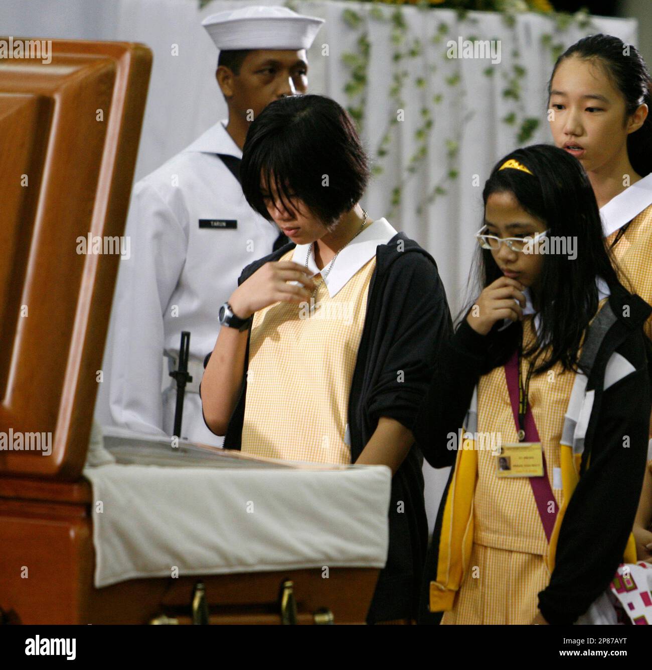 Students gesture sign of the cross as they pay their respects to late ...