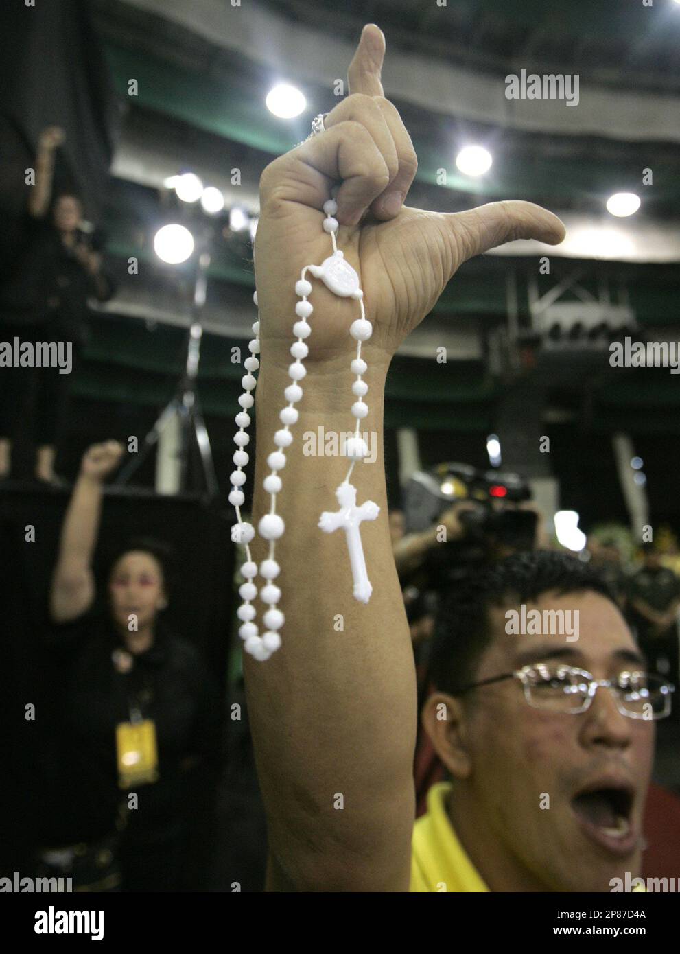 A Filipino supporter flashes the Laban sign, "Fight", while holding a ...
