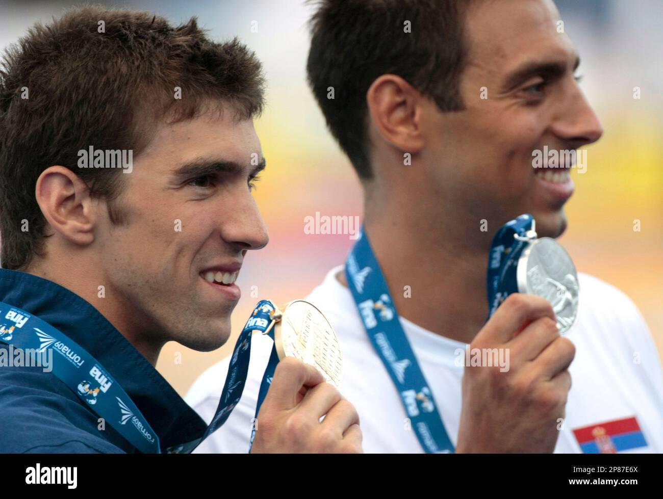 Michael Phelps of the United States, left, shows his gold medal of the ...