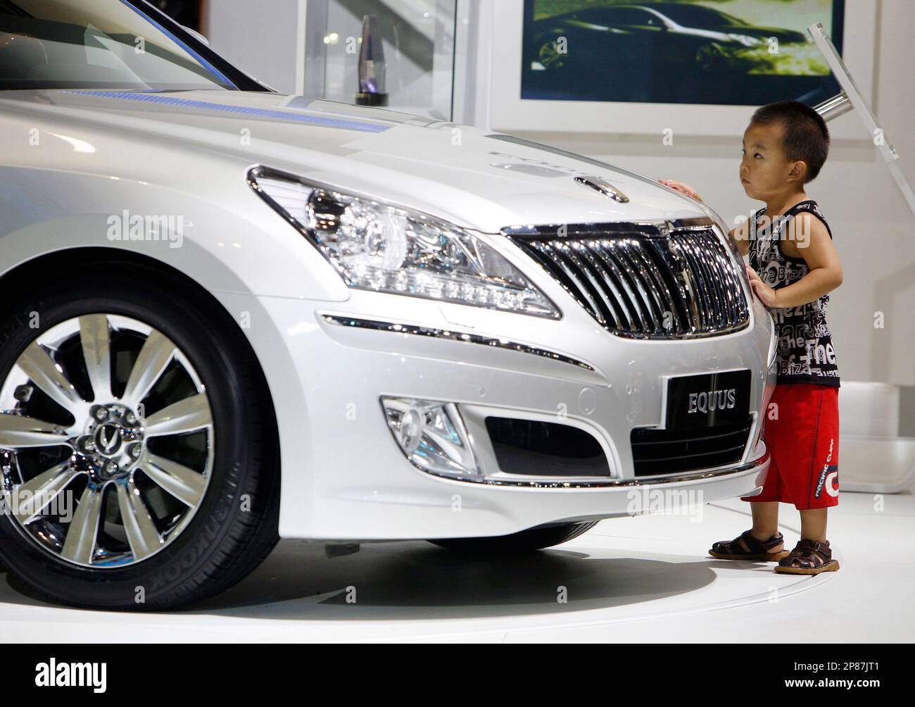 A young boy looks at a Hyundai Equus car at an auto exhibition in ...
