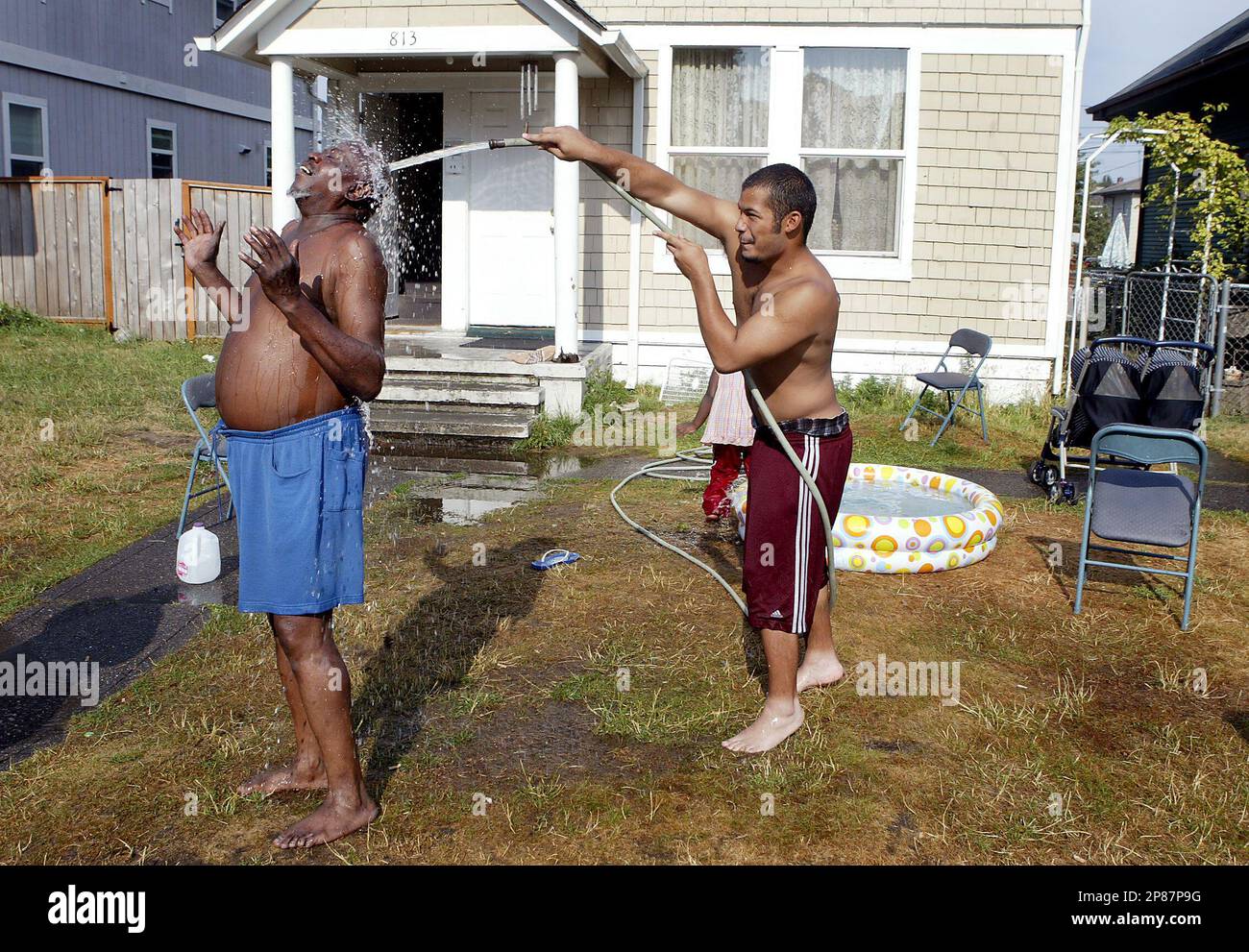 Gregory Pettus, 57, as Anthony Allen, 20, douses his head with a garden ...