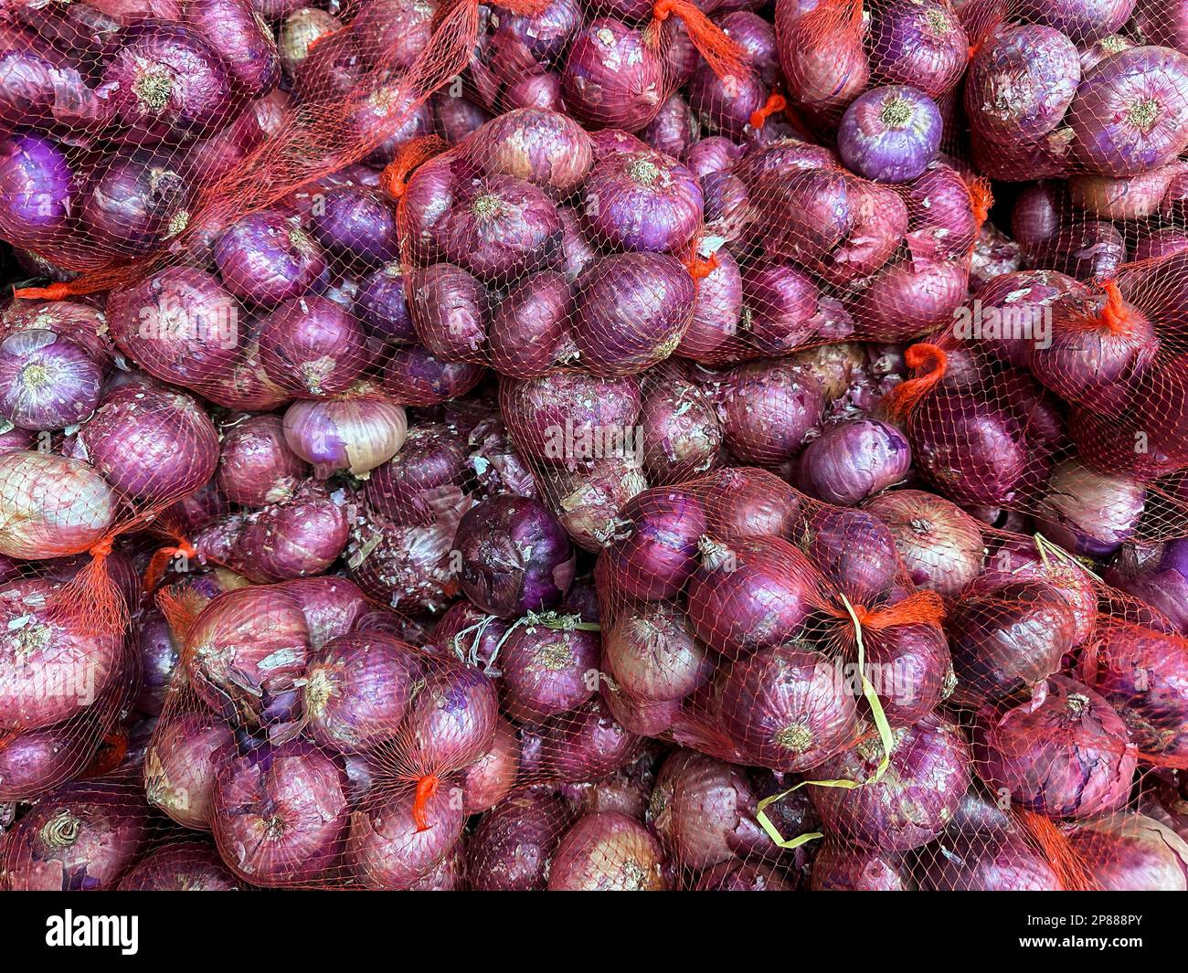 Small Indian Onion or Red Indian Onion bags for Sale at a Fresh Food Market in India. Top View ...