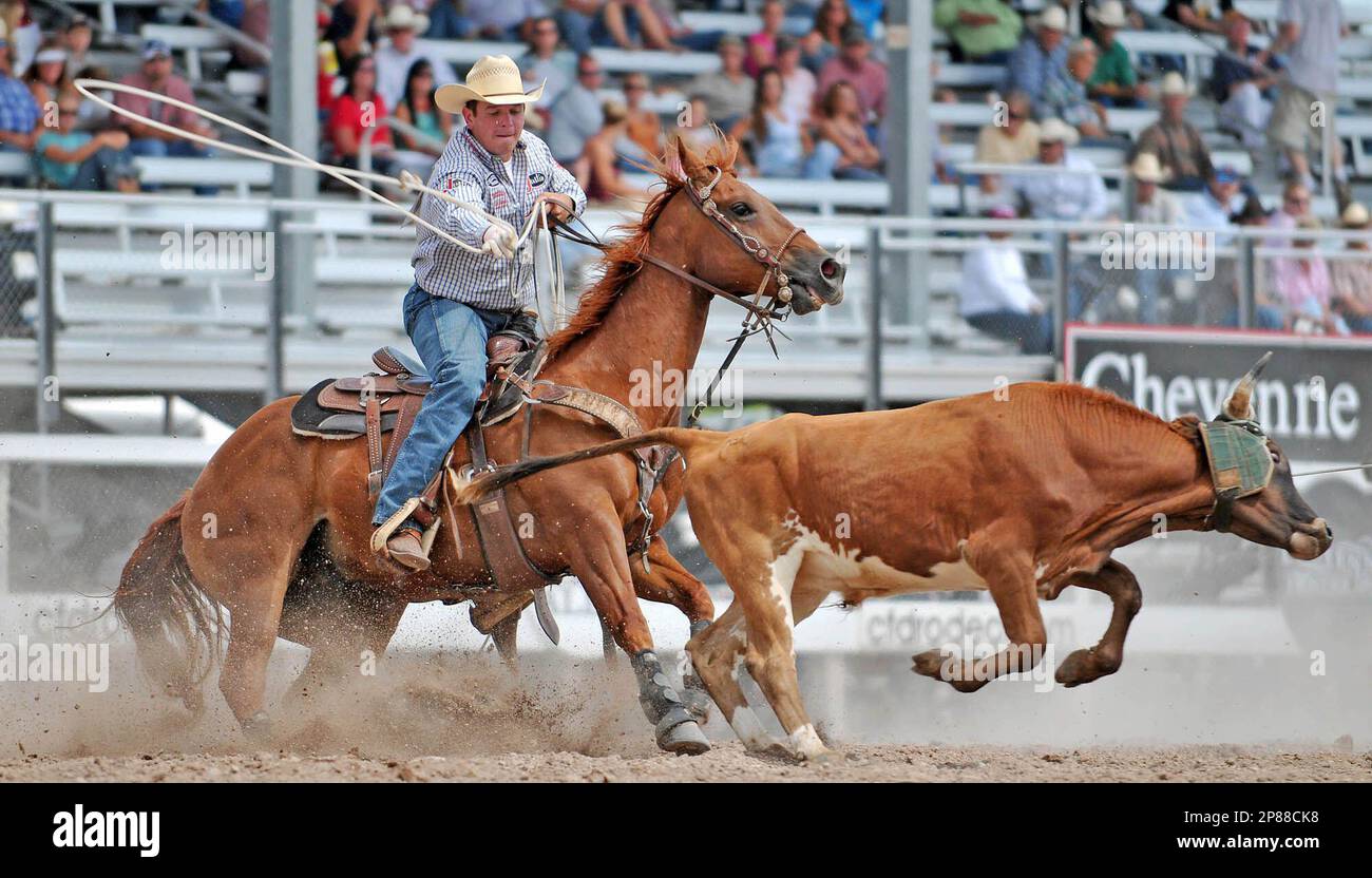 Richard Durham ropes the heels of a steer while competing with his ...