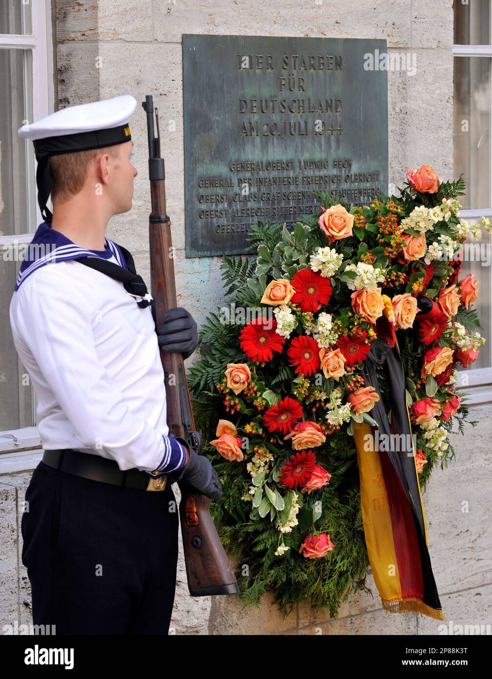 An honor guard stands beside a plaque commemorating the execution of ...