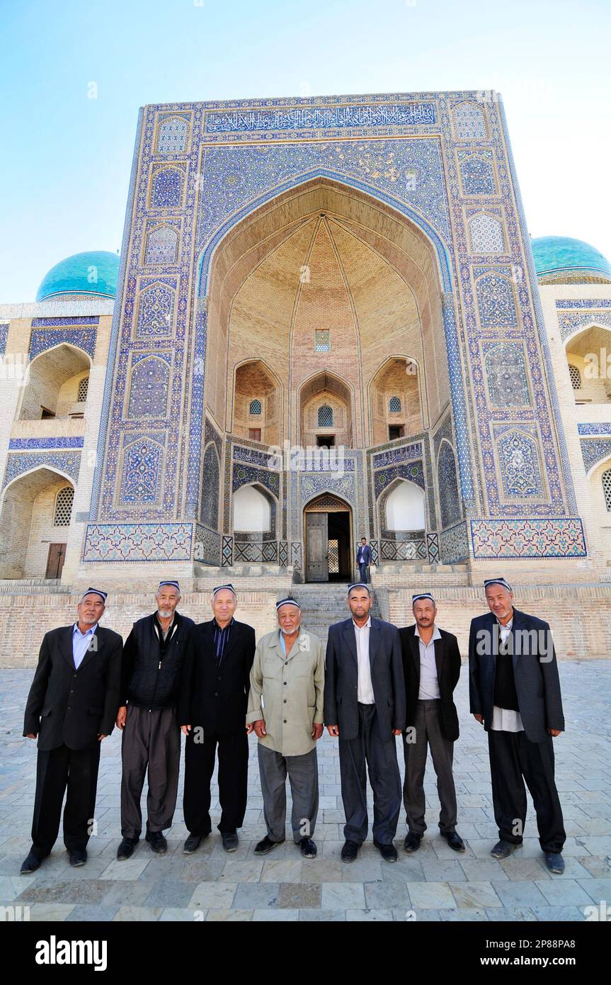 Uzbek men standing in front of the Kalan Mosque and courtyard in the ...
