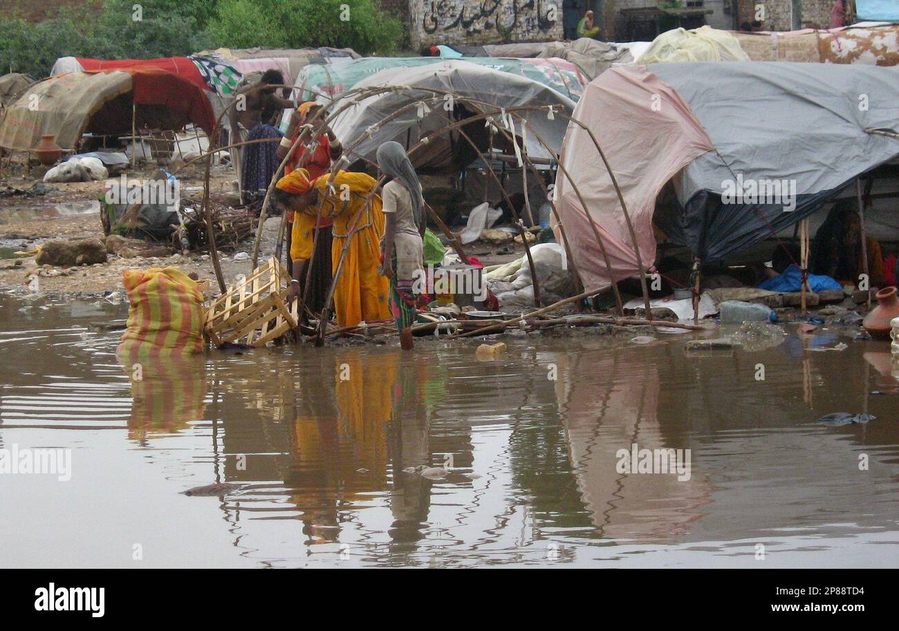 A Pakistani homeless family fixes their damaged hut caused by heavy ...
