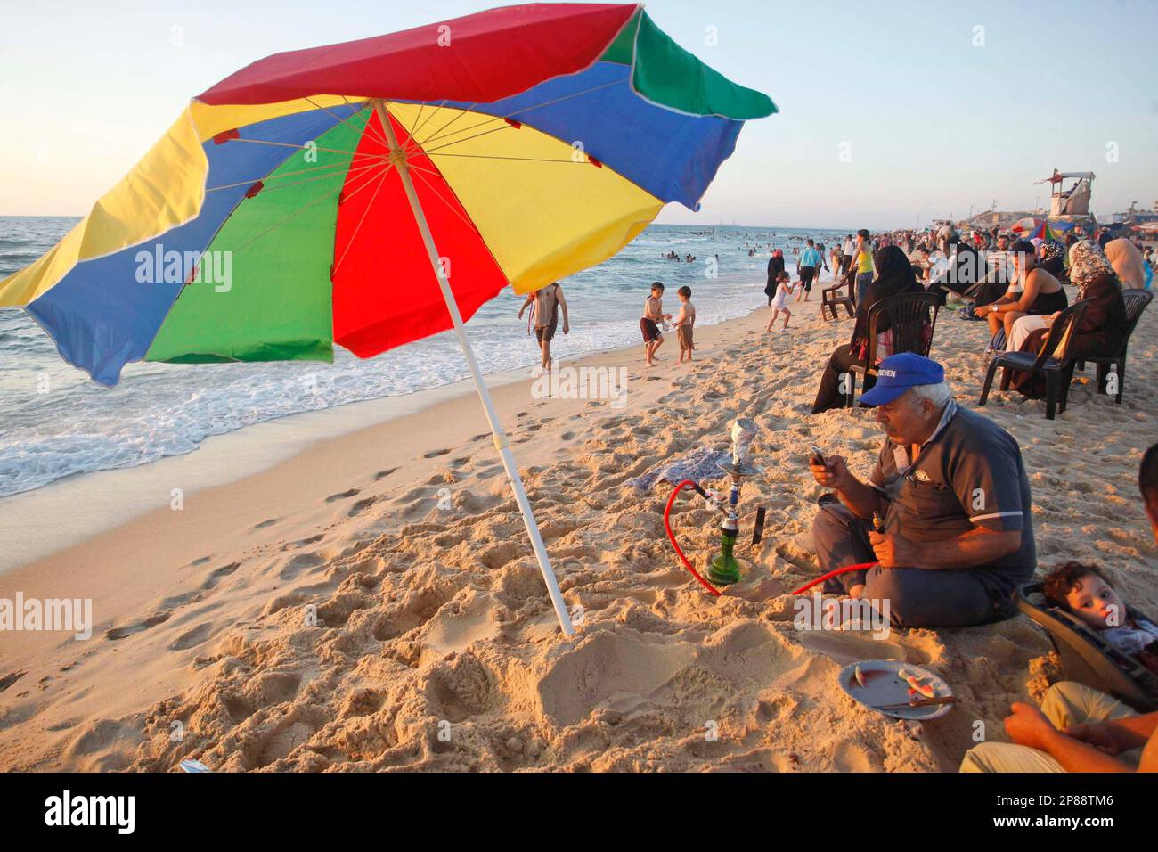 A Palestinian man smokes a water pipe on the beach in Gaza City, Friday ...