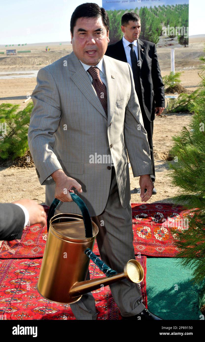 Turkmen President Gurbanguli Berdymukhamedov poses with a watering can ...