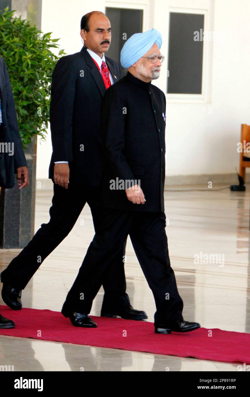 India's Prime Minister Manmohan Singh, right, is guarded by an Egyptian ...