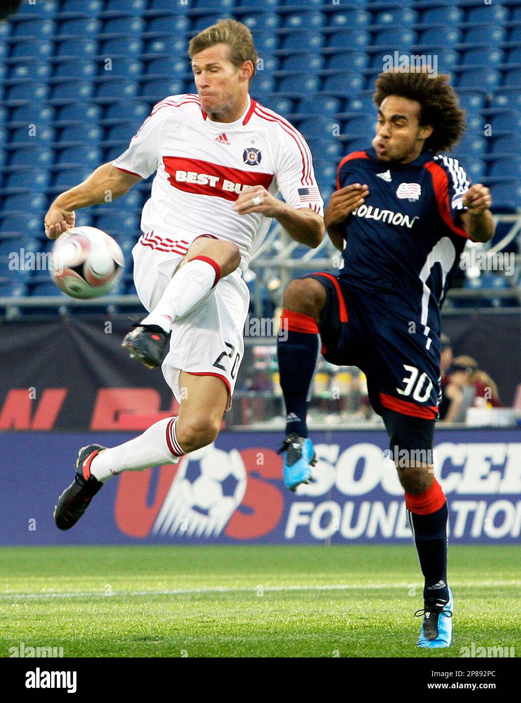 Chicago Fire's Brian McBride, left, kicks the ball away from New ...