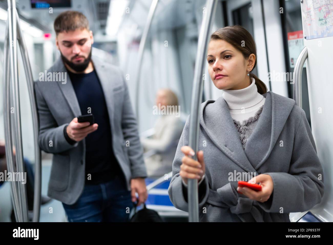 Positive woman reading from mobile phone screen in metro Stock Photo ...