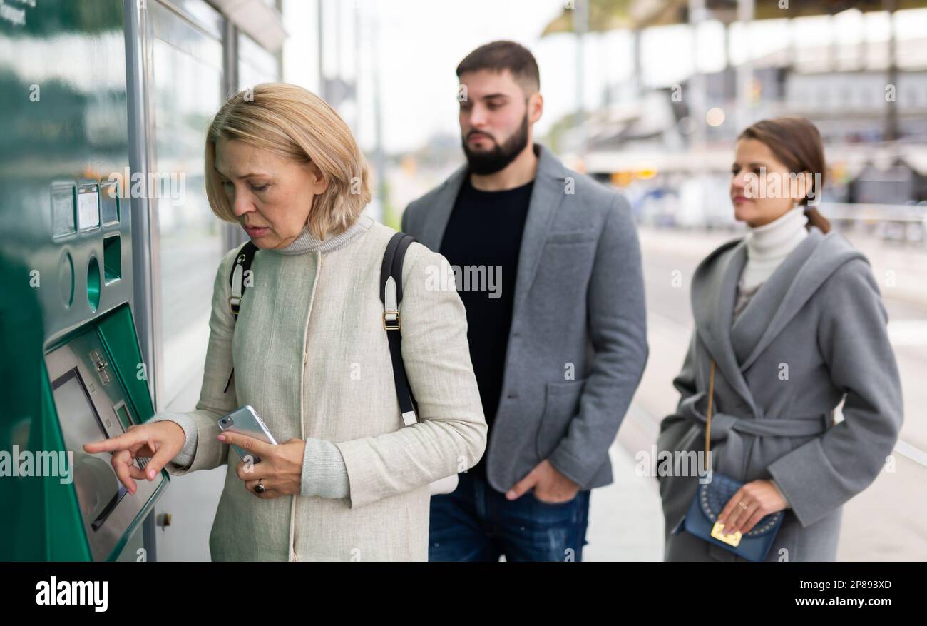 Woman using ticket vending machine Stock Photo - Alamy