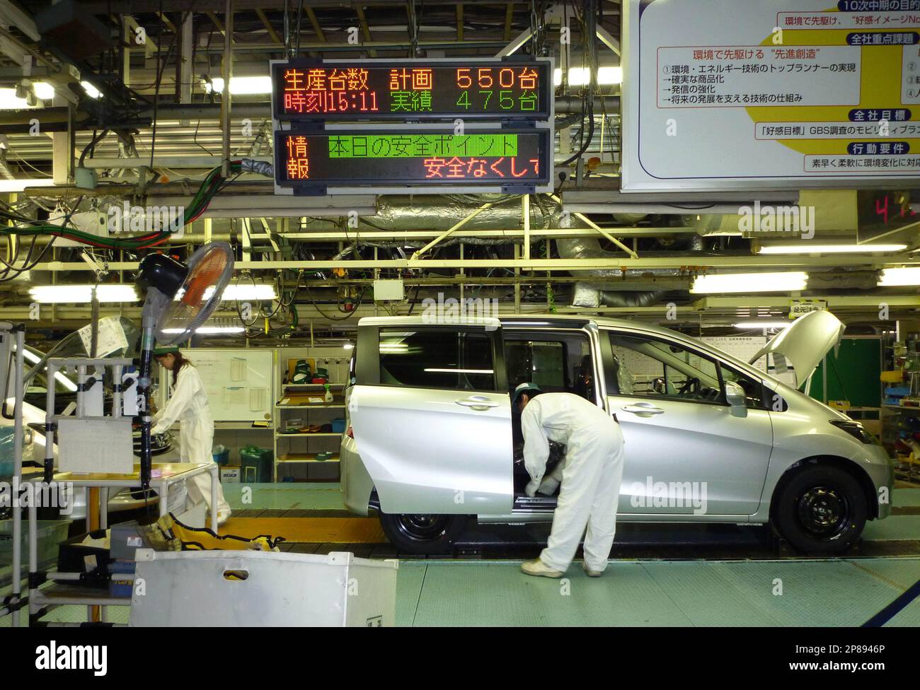 Workers check a Freed on an assembly line at Honda Motor Co.'s Saitama ...