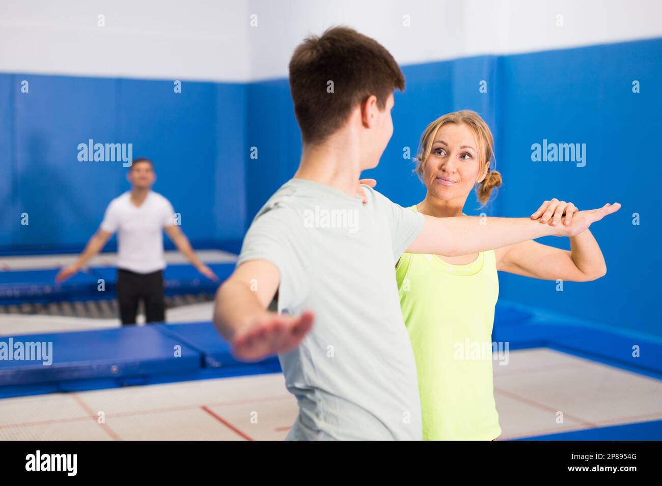 Female coach holding training with teenager in trampoline room Stock ...