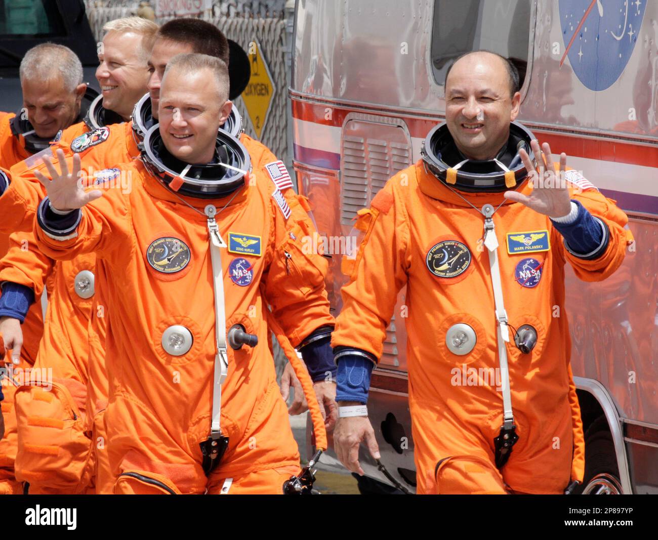 Commander Mark Polansky, right and pilot Douglas Hurley, left wave as ...