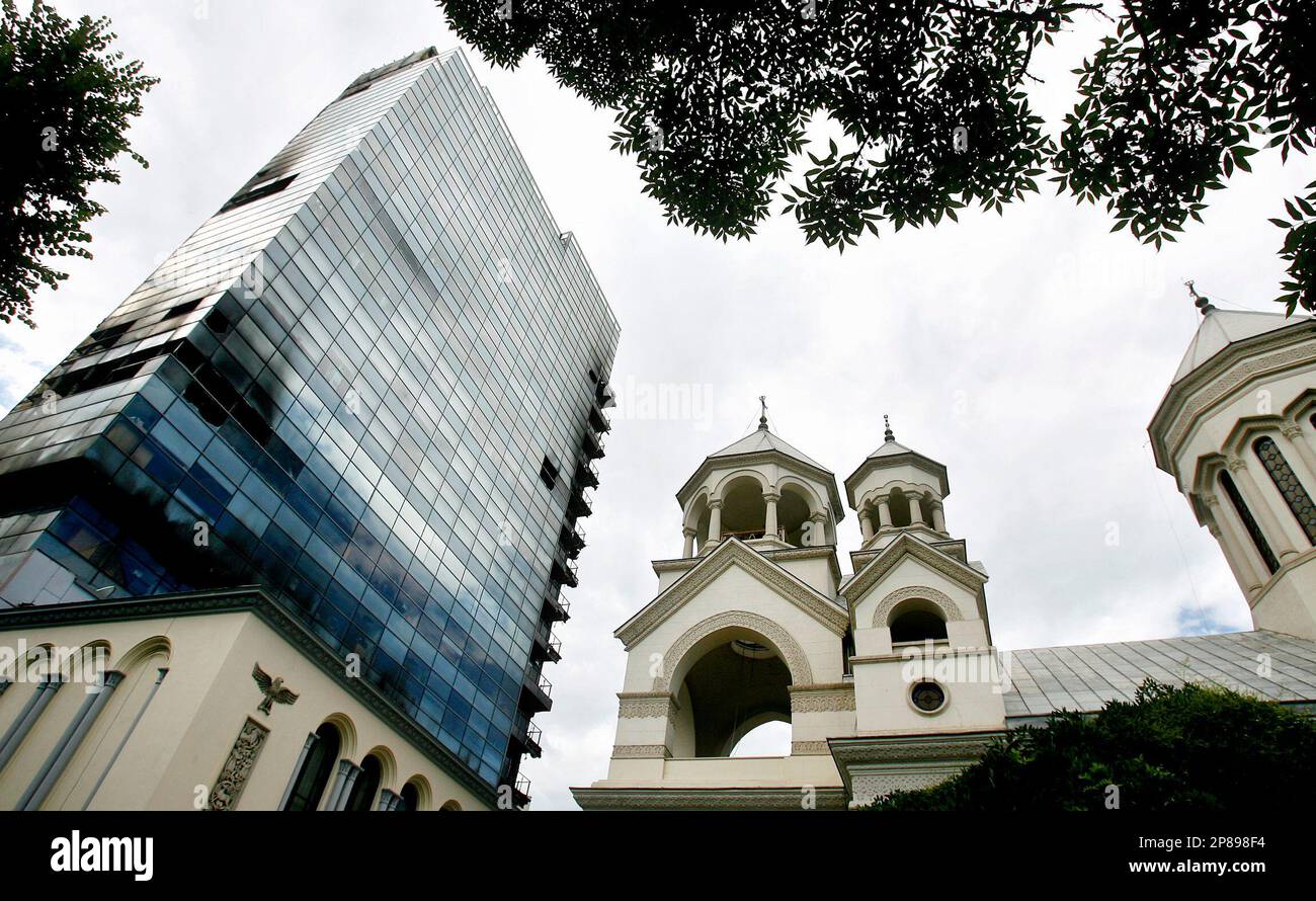 A fire damaged office building, left, is seen in Bucharest, Romania ...