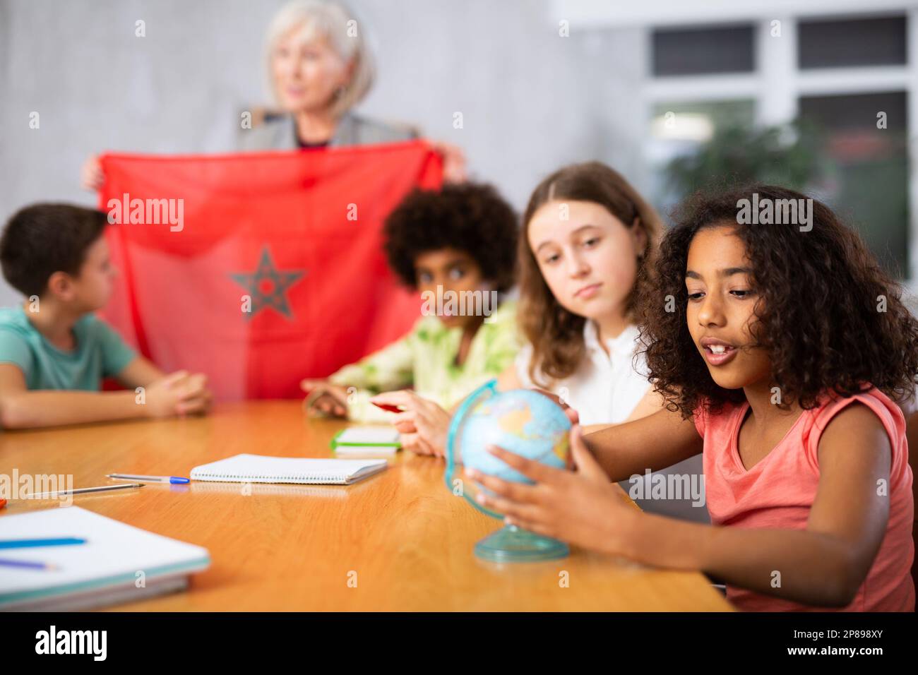 Female teacher showing moroccan flag to kids in geography class Stock ...