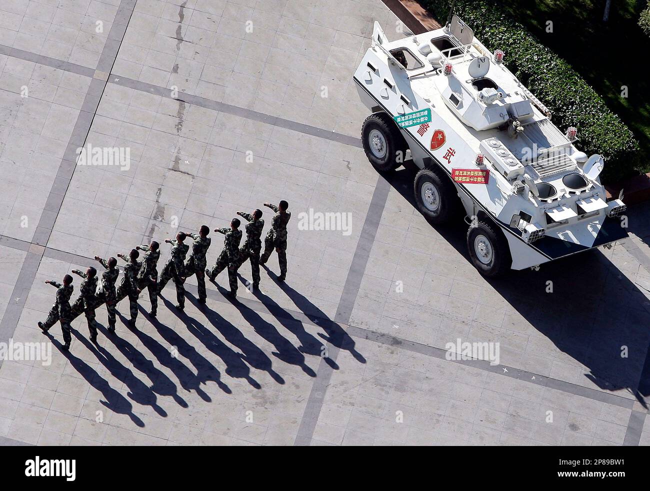 Paramilitary police officers exercise near an armed police APC at the ...