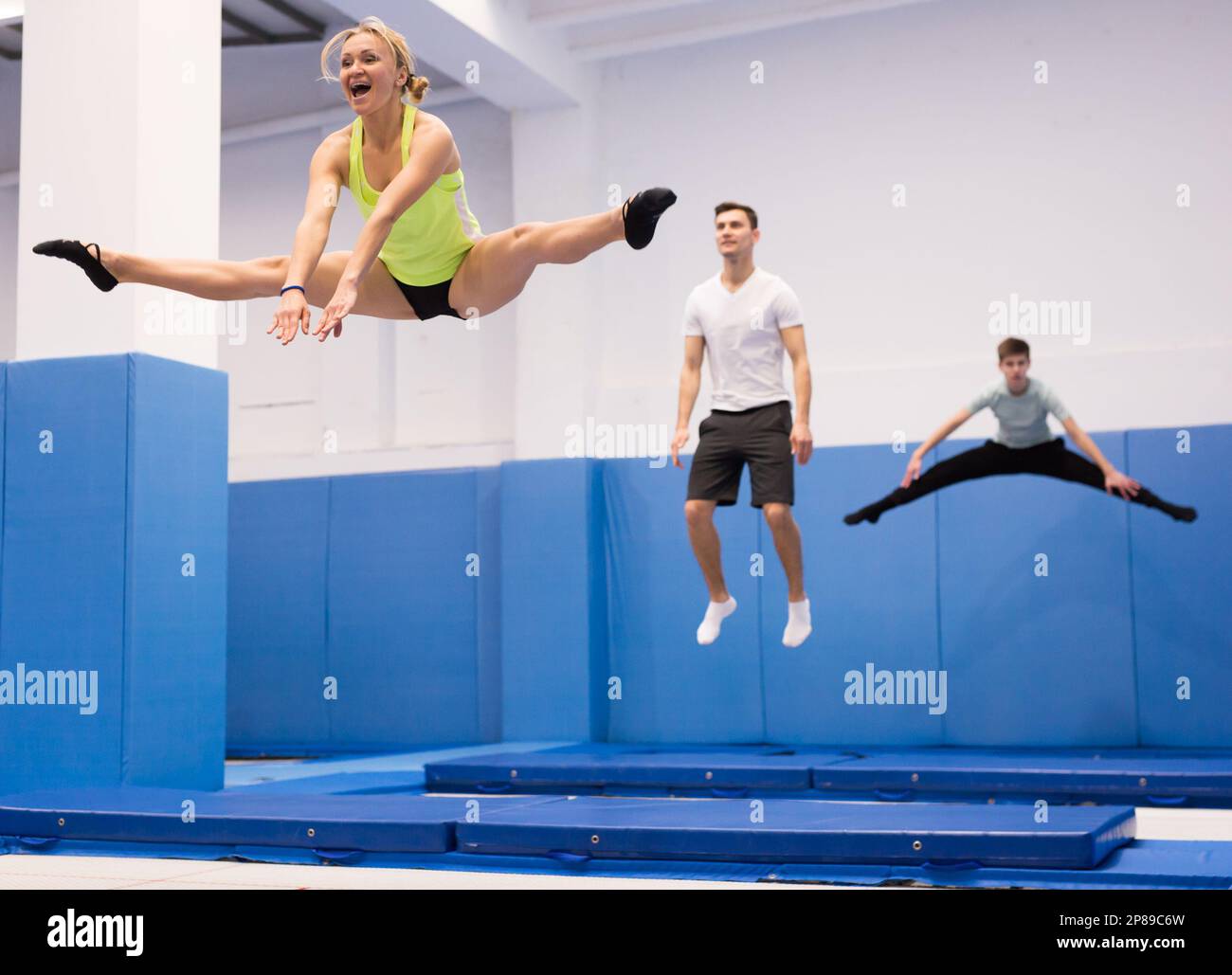 Sports girl training side split on trampoline Stock Photo - Alamy