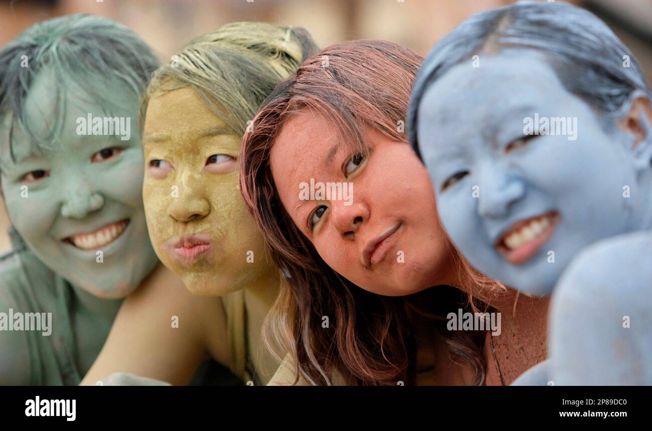 Asian tourists make up with color mud during the Boryeong Mud Festival ...