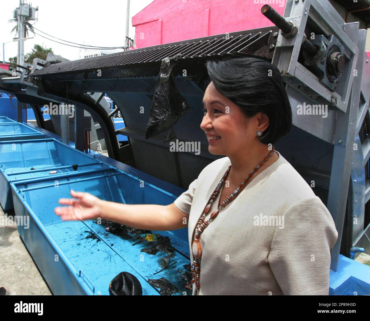 President Gloria Macapagal Arroyo gestures as she observes how garbage ...