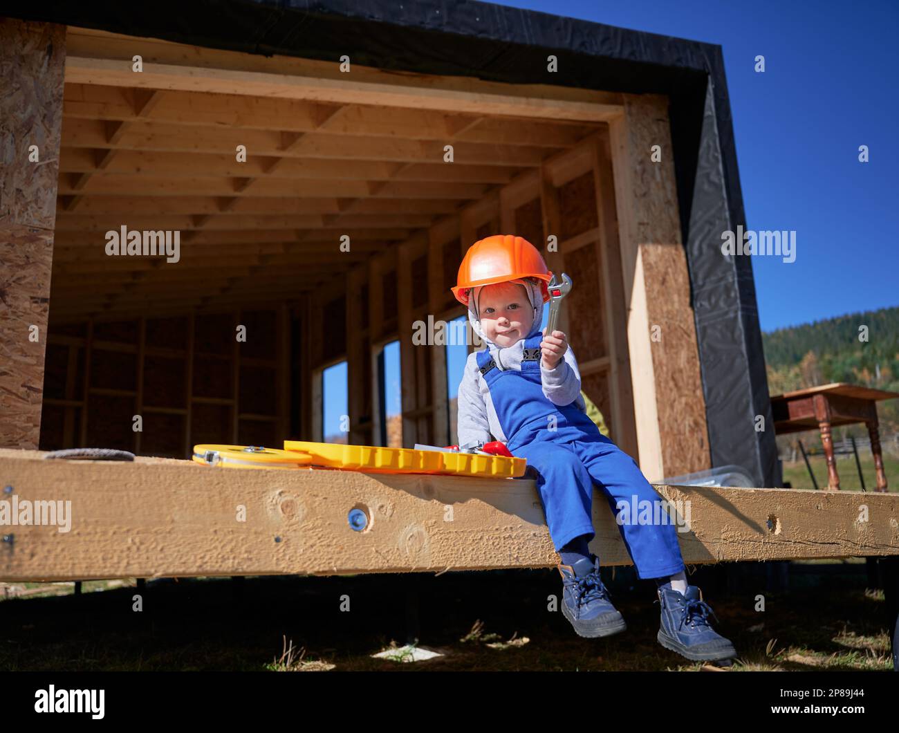 Boy toddler playing as builder on construction site. Child carpenter in ...