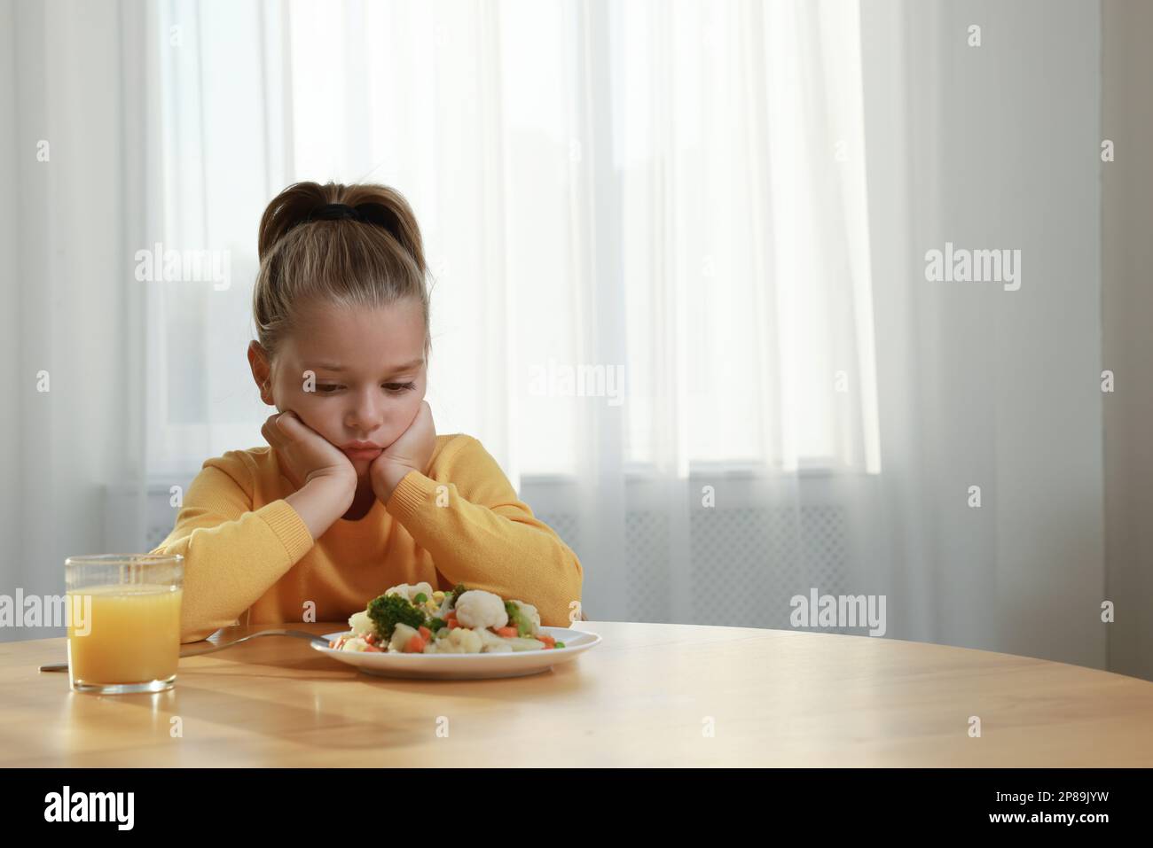 Cute little girl refusing to eat vegetable salad at home, space for ...