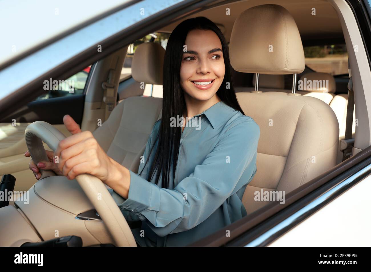 Beautiful young driver sitting in modern car Stock Photo - Alamy