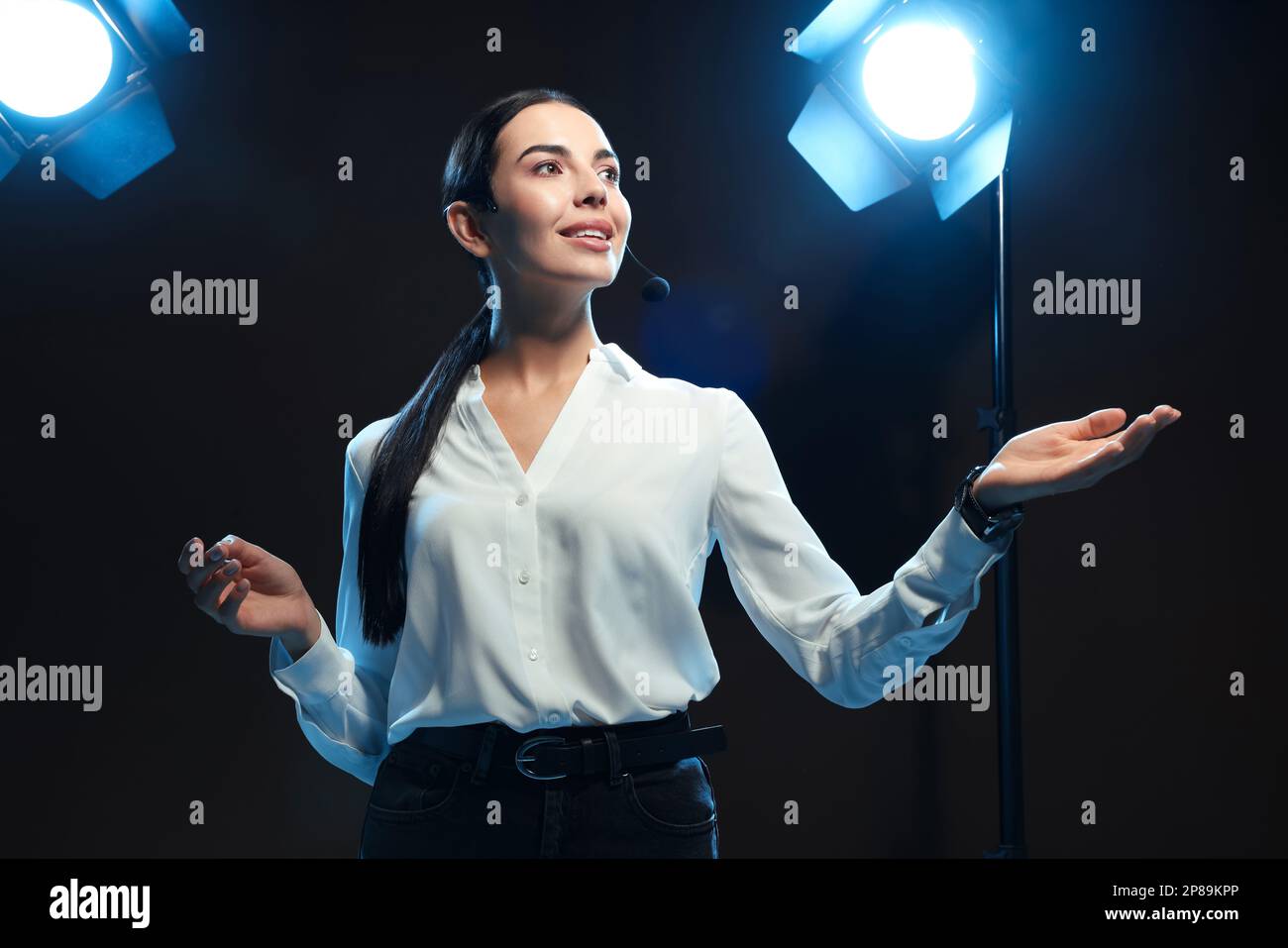 Motivational speaker with headset performing on stage Stock Photo - Alamy