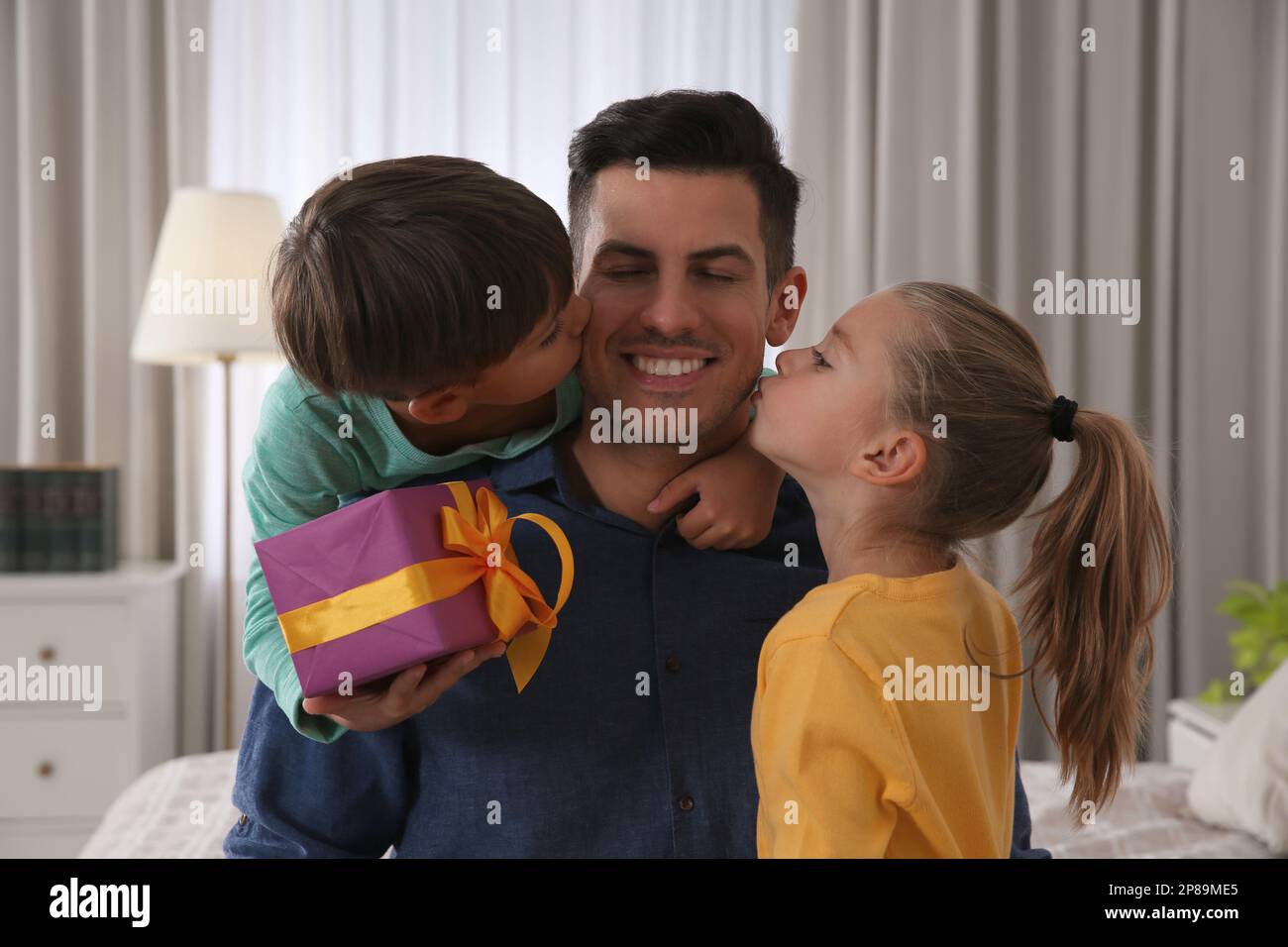 Man receiving gift for Father's Day from his children at home Stock ...