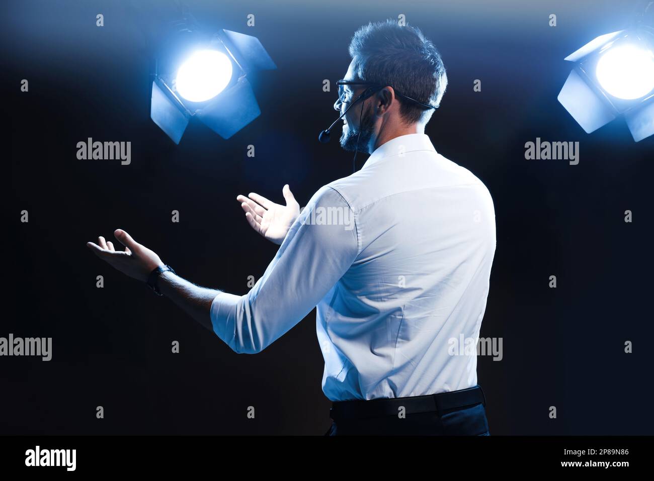 Motivational speaker with headset performing on stage Stock Photo - Alamy