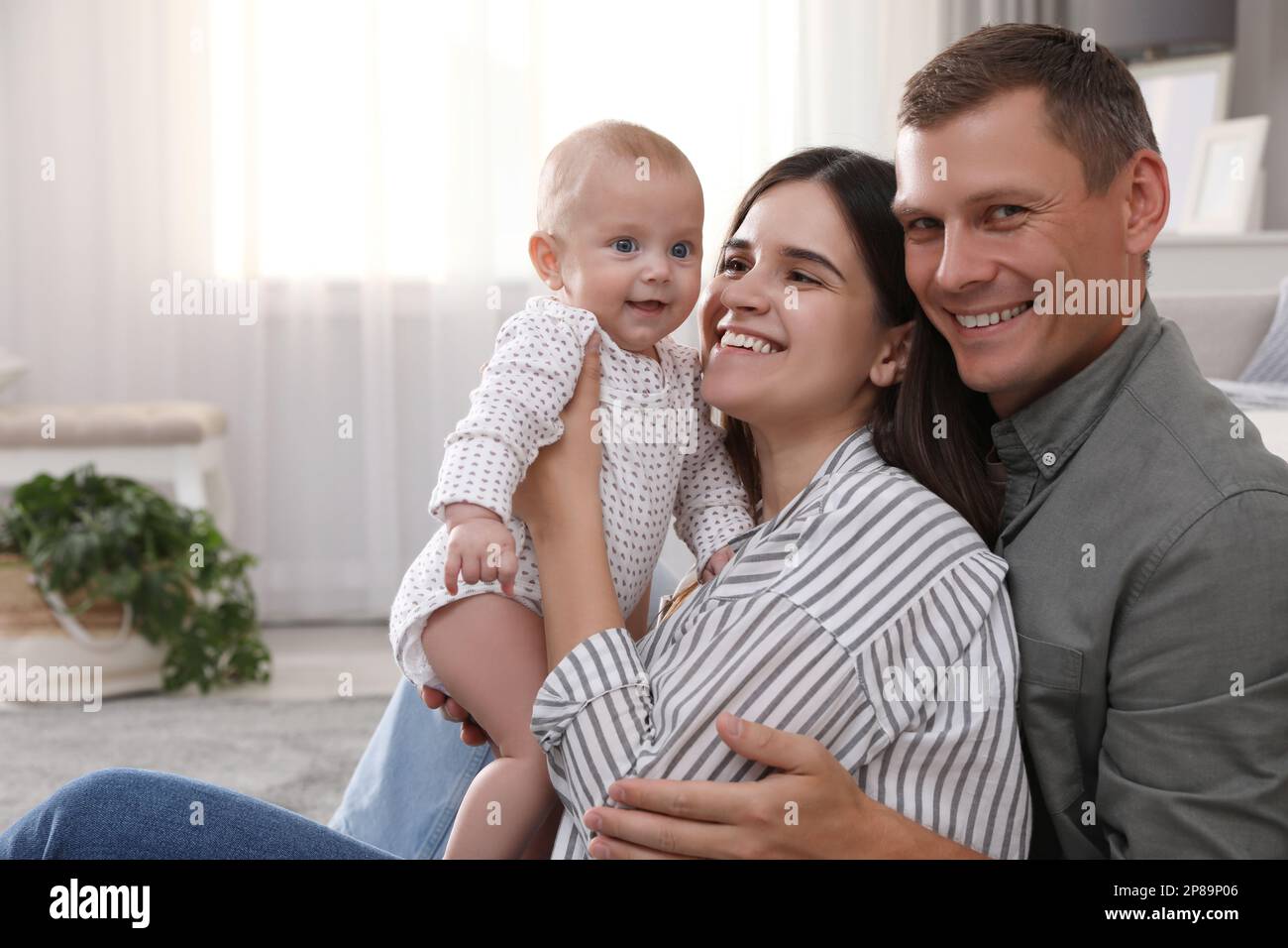 Happy family with their cute baby in living room at home Stock Photo ...