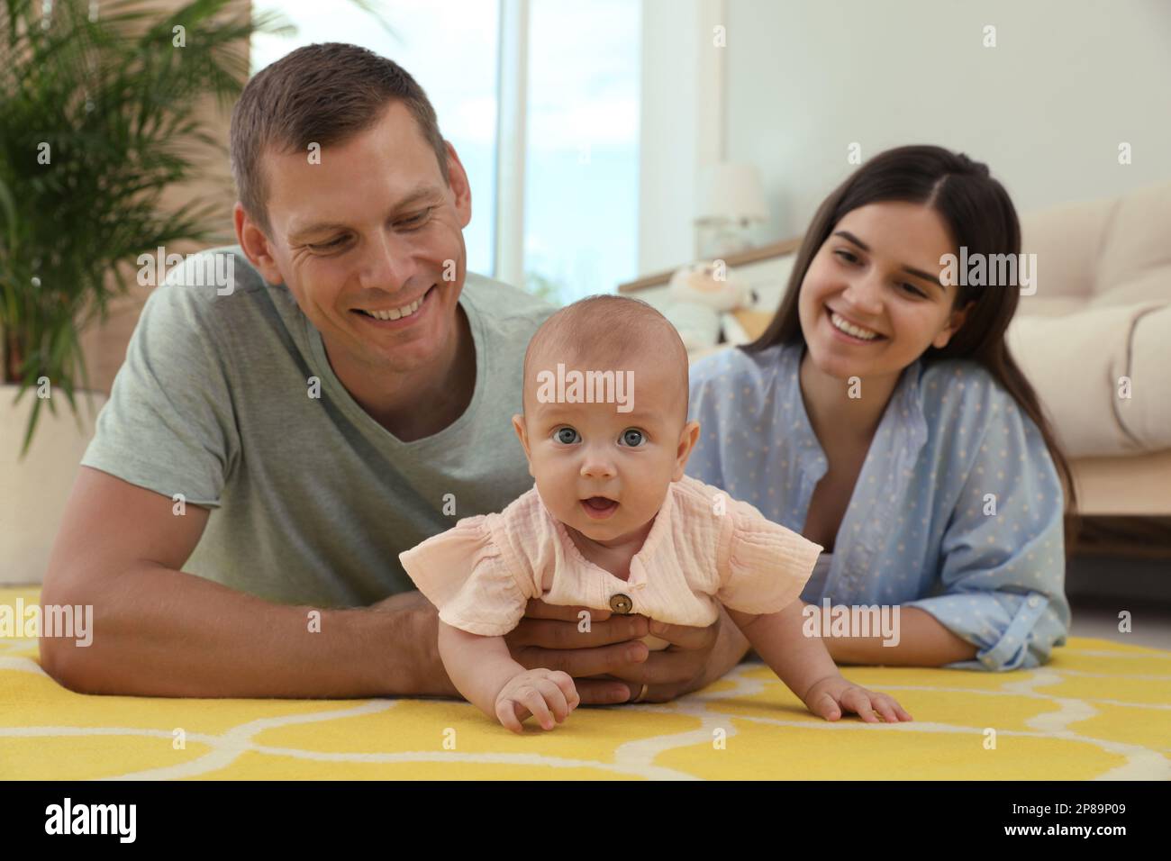 Happy family with their cute baby in living room at home Stock Photo ...