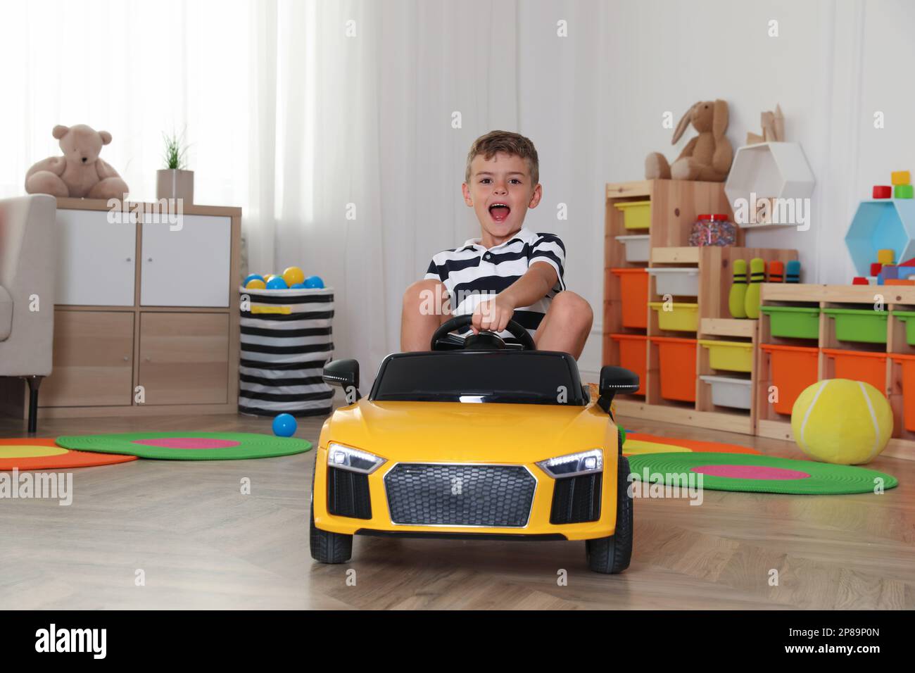 Emotional little boy driving big toy car at home Stock Photo - Alamy