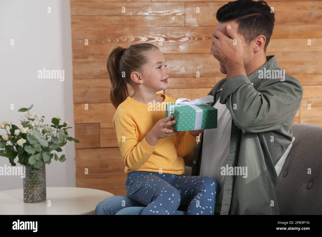Man receiving gift for Father's Day from his daughter at home Stock ...