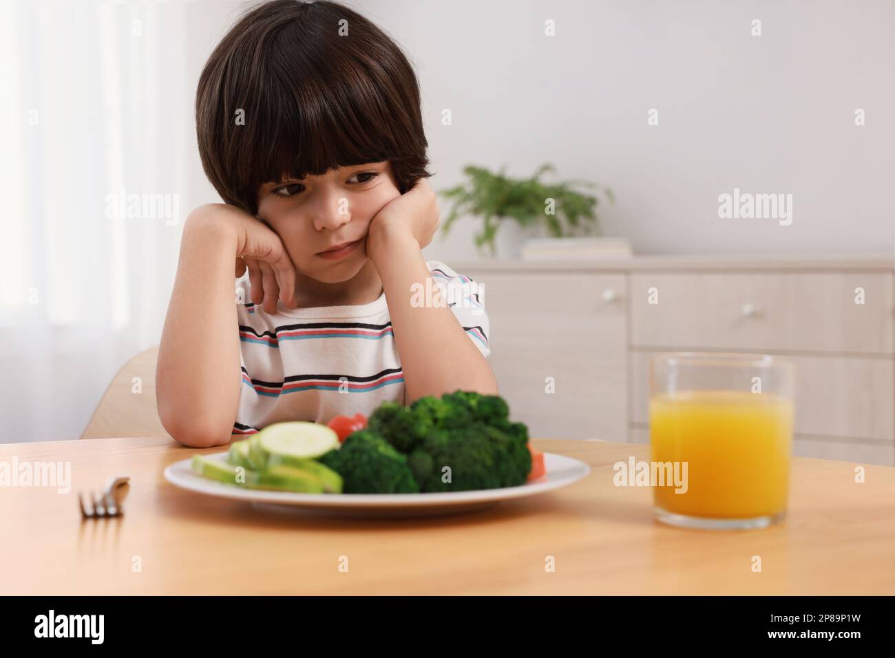 Cute little boy refusing to eat vegetables at home Stock Photo - Alamy