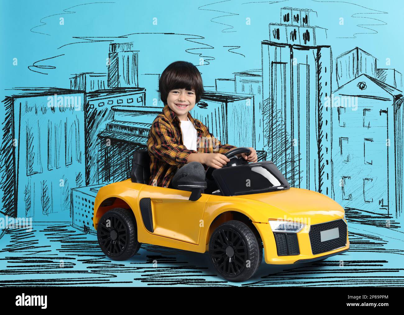 Cute little boy driving toy car and drawing of city on light blue ...