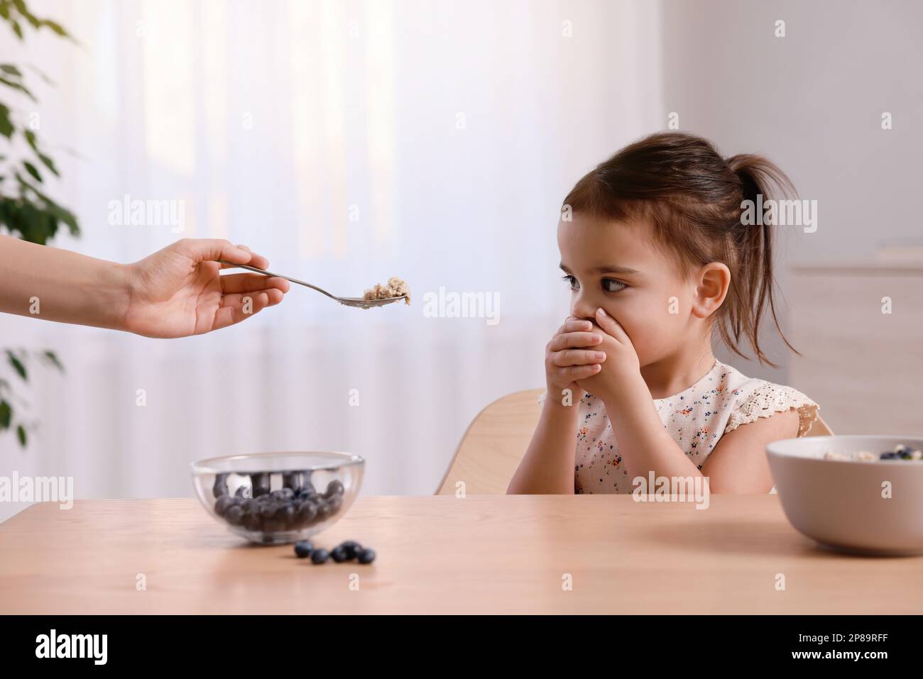 Cute little girl covering her mouth and refusing to eat breakfast at ...