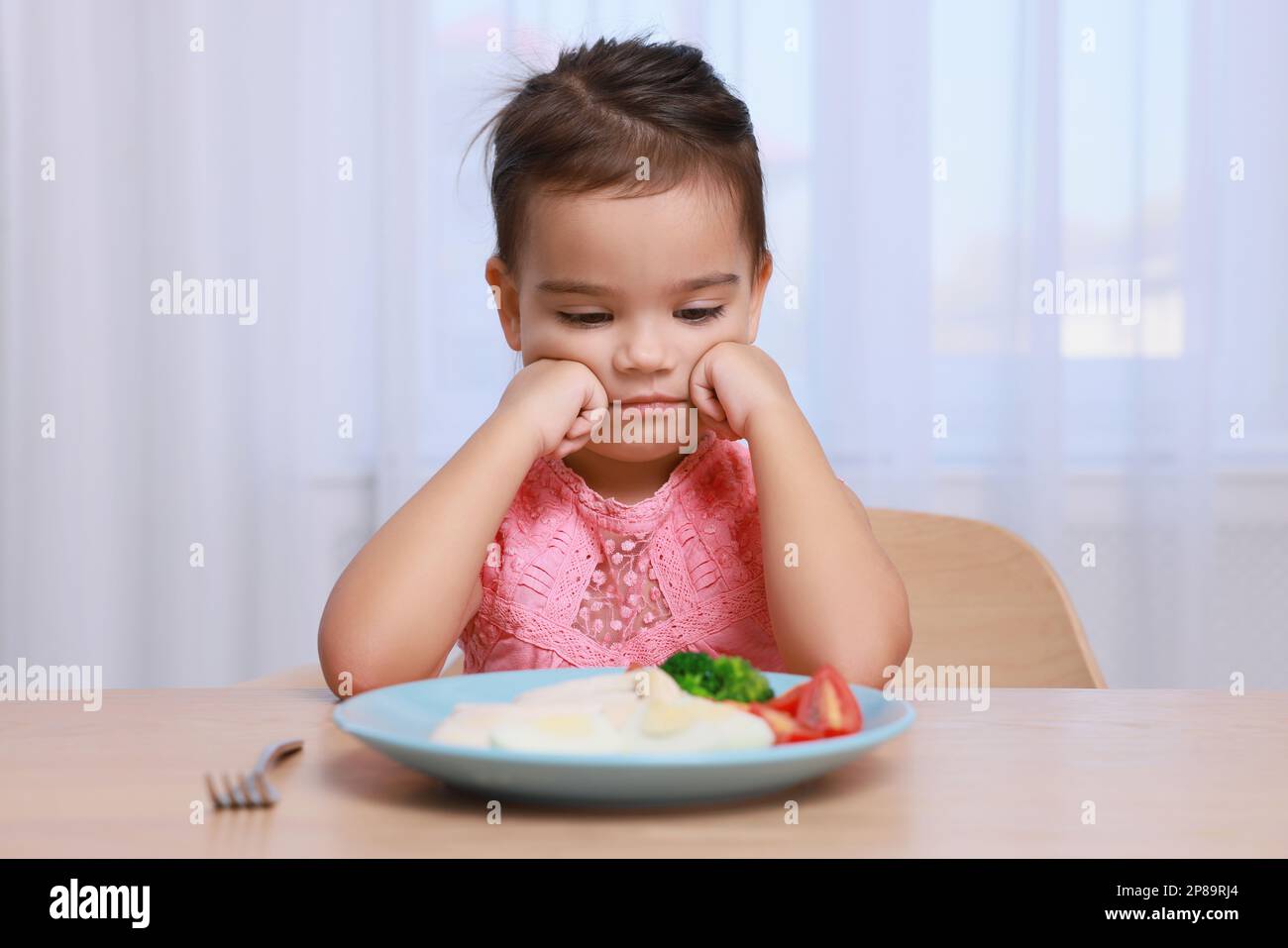 Cute little girl refusing to eat her breakfast at home Stock Photo - Alamy